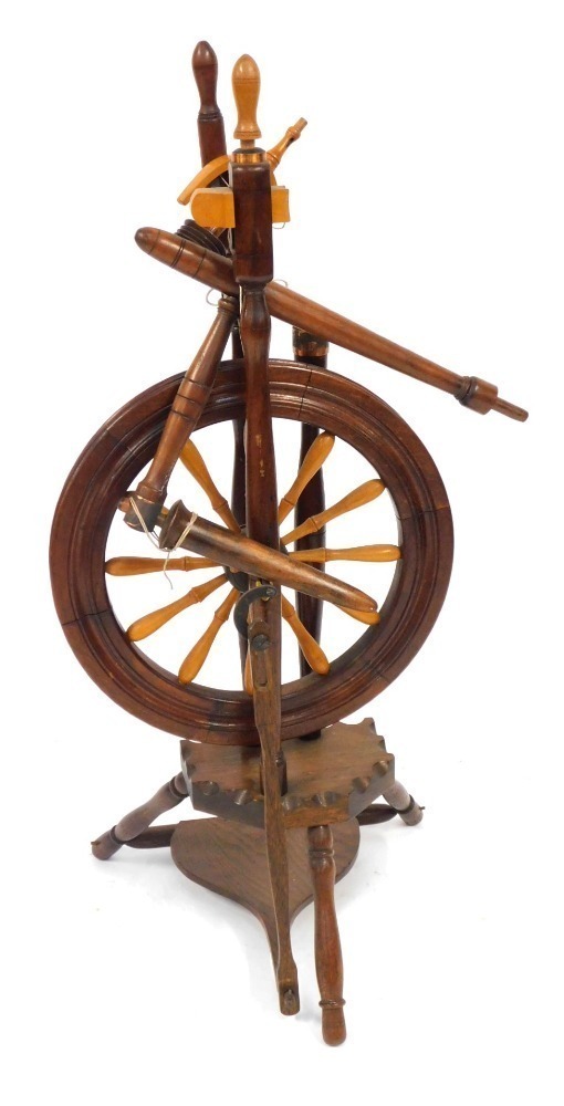 An oak and mahogany spinning wheel, with attachments and harp foot ...