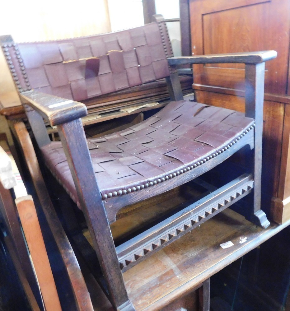 An armchair, with oak frame and cross hatched leather straps, with ...