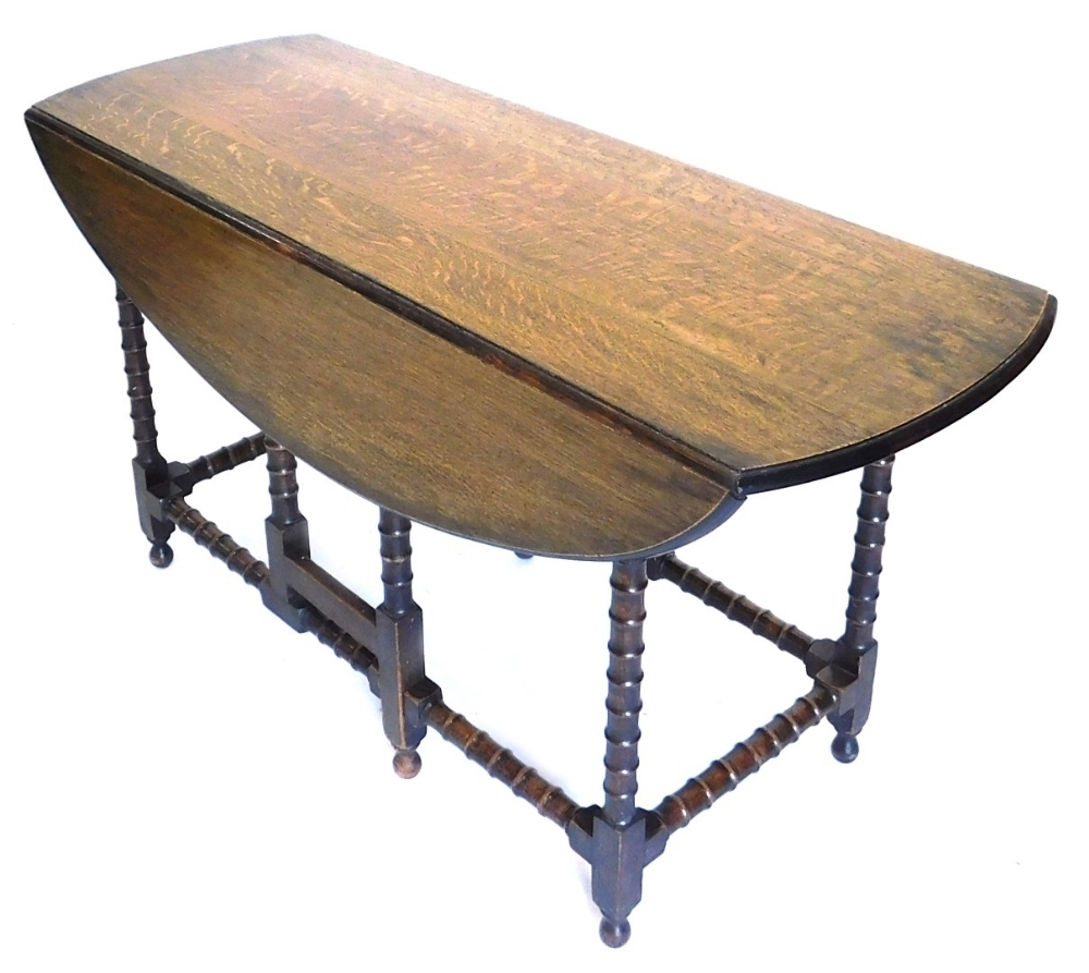 An 18thC style oak gateleg drop leaf table, the D end top on barley ...
