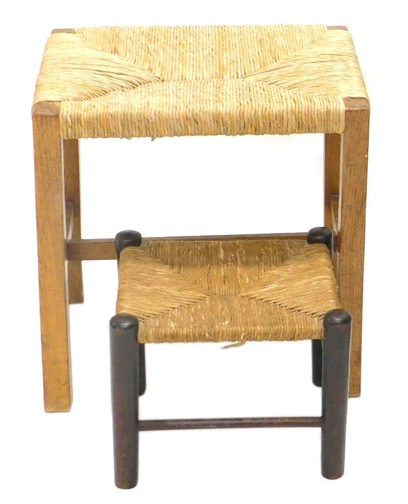 An early 20thC stool, with rope top, on turned legs joined by ...