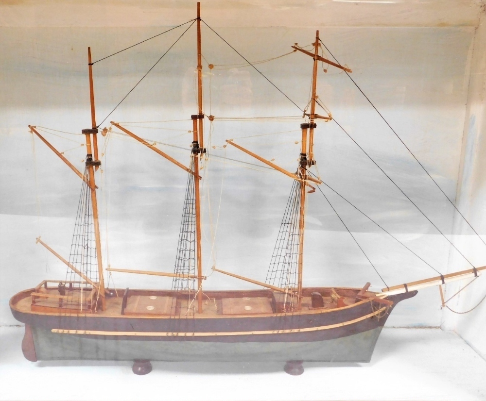 A wooden scale model of a barque sailing vessel, contained in a Perspex ...