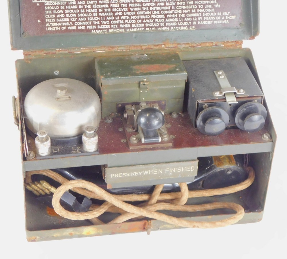 A World War II cased military telephone, in green cased tin, stamped MK ...