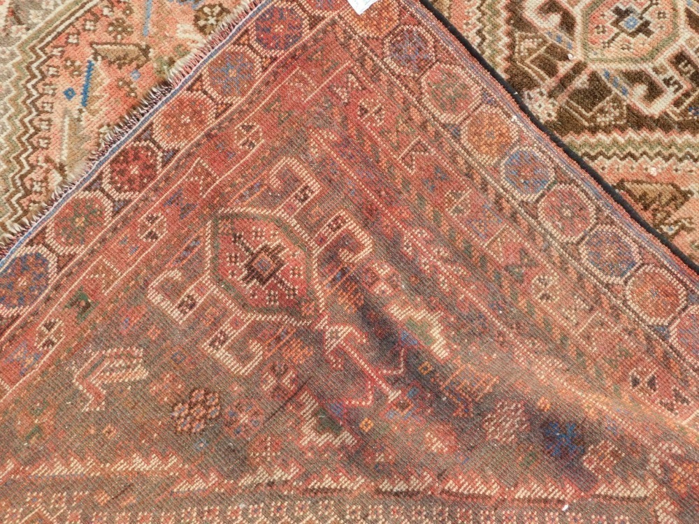 A Persian red ground rug, the central field decorated with a medallion ...