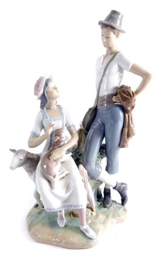 A large 20thC Lladro pottery figure group, farm hands, sheep and lamb ...