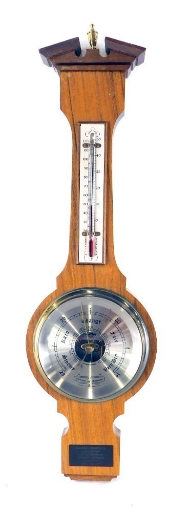 A 20thC two dial barometer, in a broken pedimented case, with brass urn ...