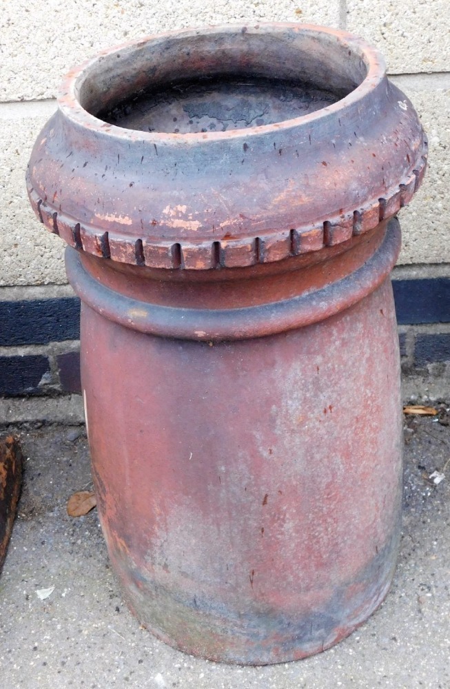 A terracotta chimney stack, of cylindrical form, with a shaped top ...
