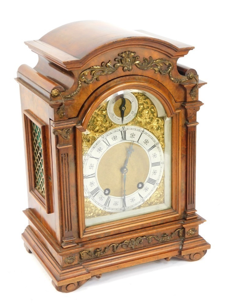 A late 19thC walnut cased mantel clock, with an arched top with brass ...