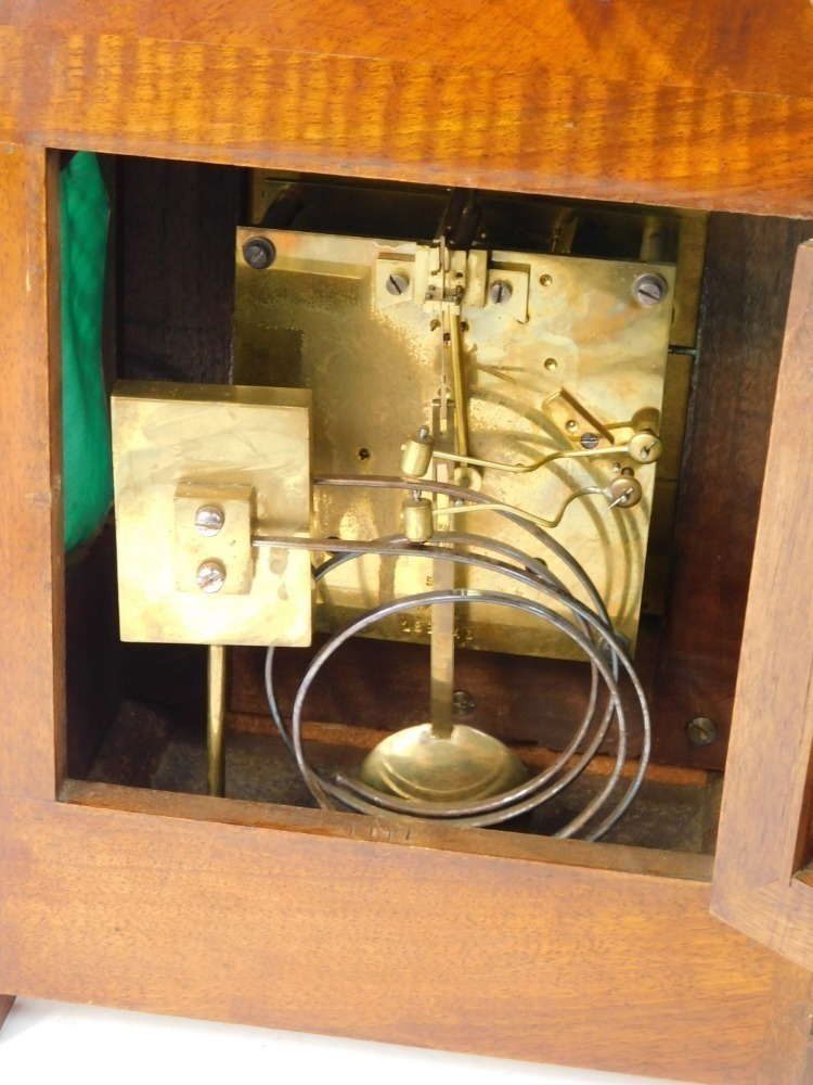 A late 19thC walnut cased mantel clock, with an arched top with brass ...