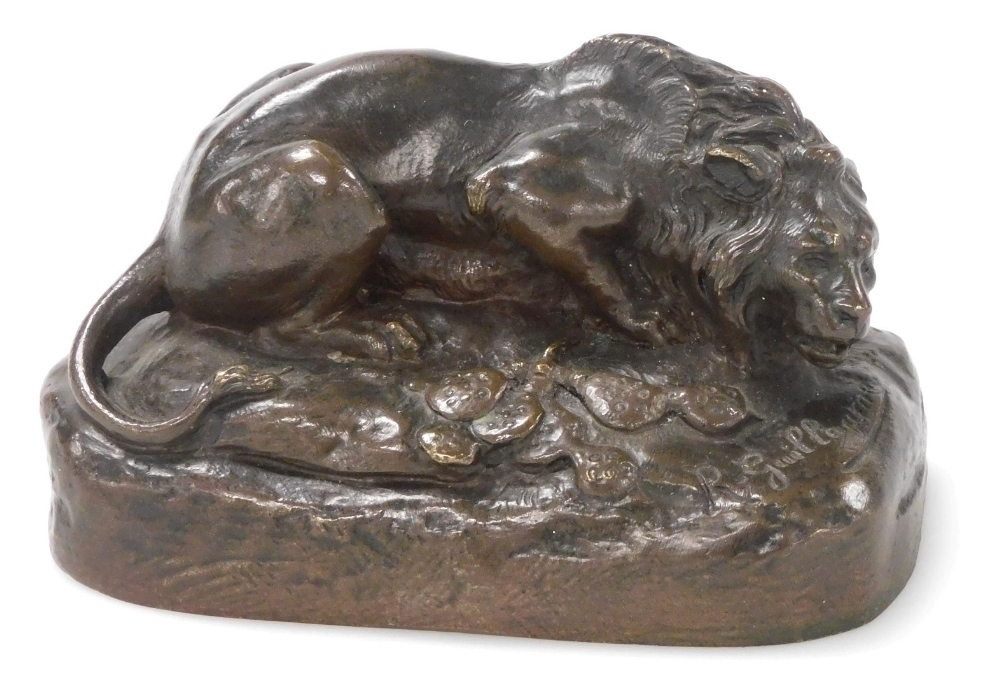 A 19thC cast bronze sculpture of a recumbent lion, on a naturalistic ...