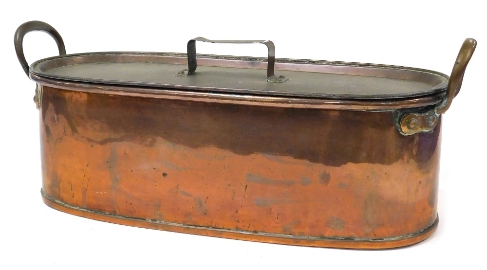 A large two handled copper fish kettle, of plain oval design with strap ...