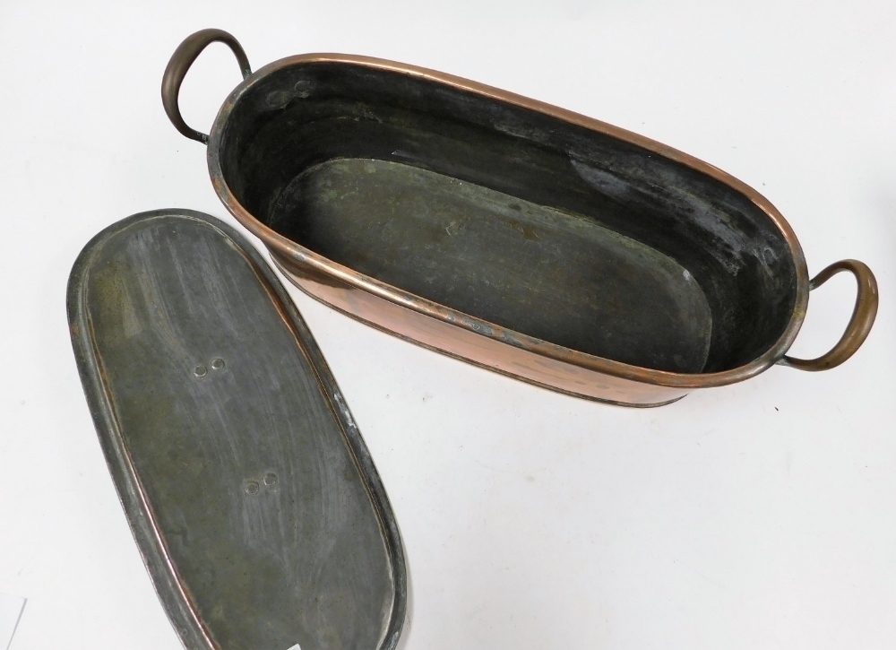 A large two handled copper fish kettle, of plain oval design with strap ...