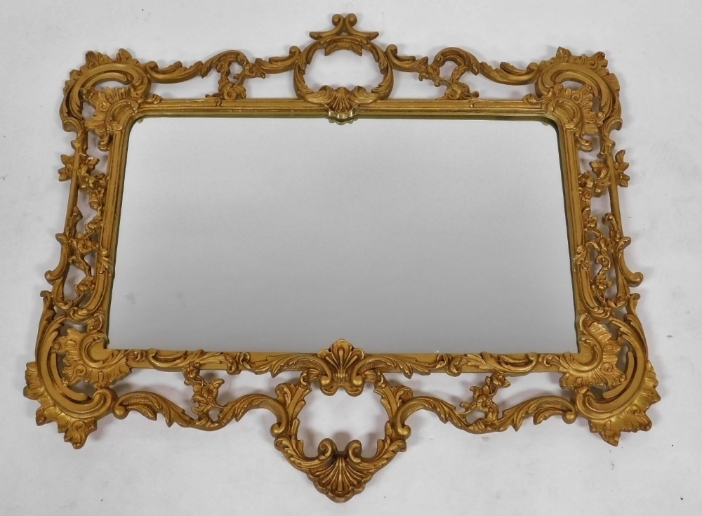 A 20thC gilt cast metal wall mirror, the ornate rococo style frame ...