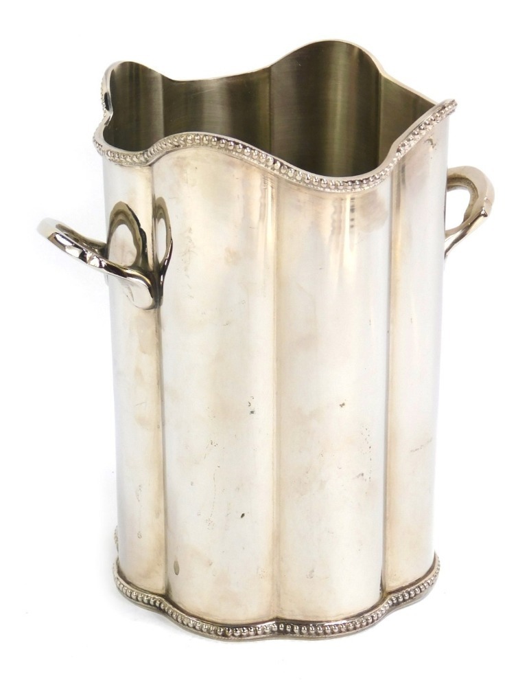 A silver plated twin handled wine bottle holder, of fluted form, with a ...