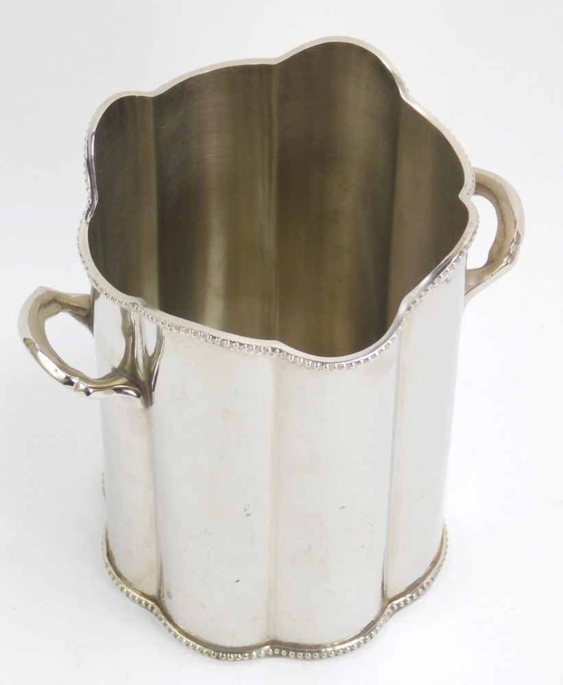 A silver plated twin handled wine bottle holder, of fluted form, with a ...