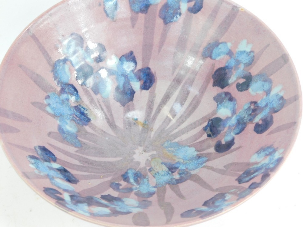 A studio pottery floral bowl, decorated with irises against a pink ...