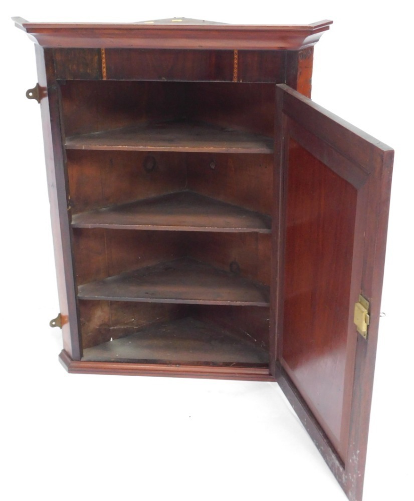 A Georgian mahogany and rosewood hanging corner cabinet, the outswept ...