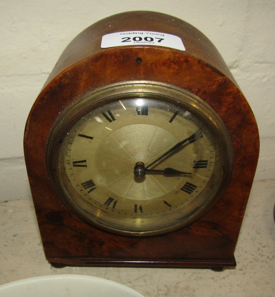 An early 20thC walnut cased mantel clock, with a domed top, with a ...