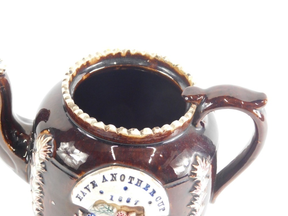 A Bargeware treacle glazed pottery teapot and cover, the body raised ...