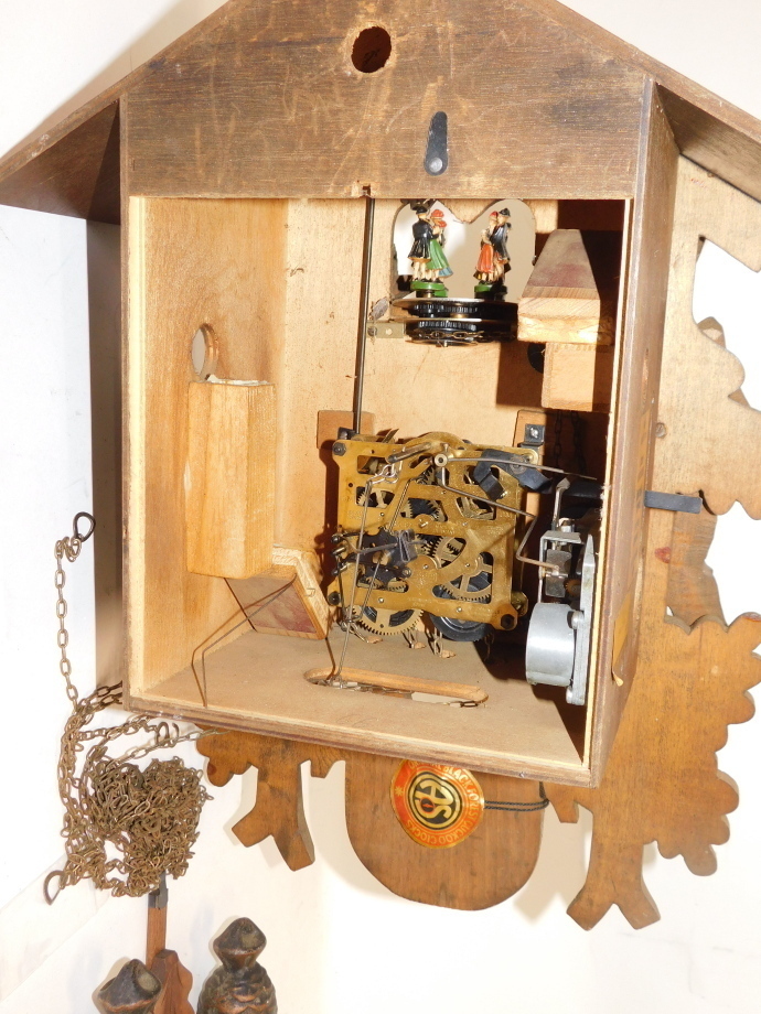 A Black Forest dancer and cuckoo clock, the pedimented case flanked by ...