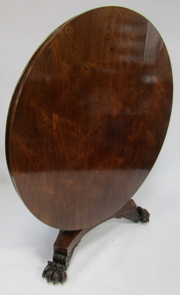A William IV rosewood circular breakfast table, the tilt top above a ...