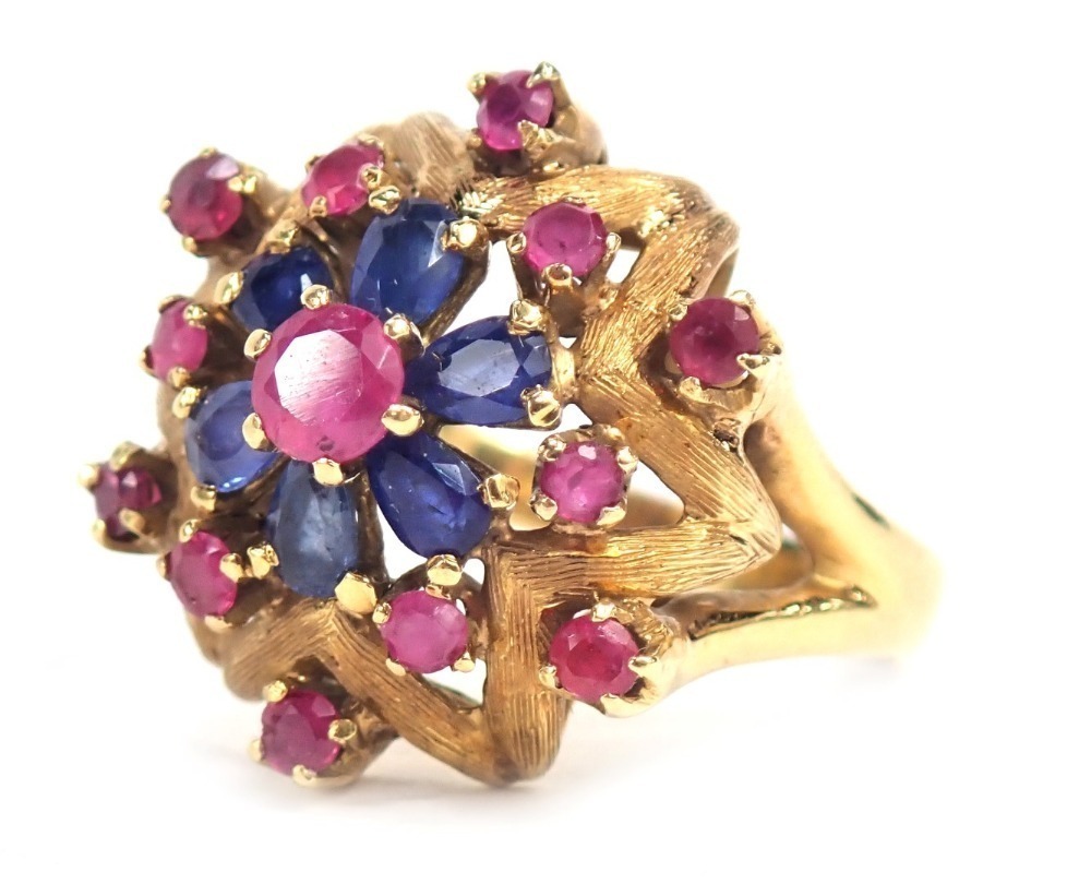 A sapphire and garnet cluster ring, with a fluted flower centre, with ...