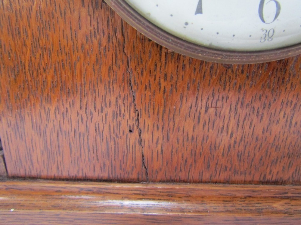 An early 20thC oak cased mantel clock, with a white enamel numeric dial ...