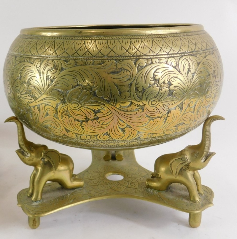 An Indian engraved brass bowl supported by three elephant figures, a ...