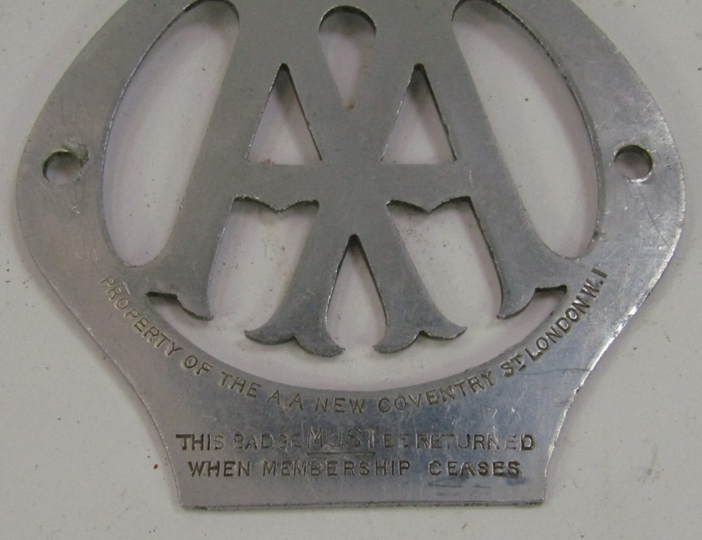 Three AA car badges.