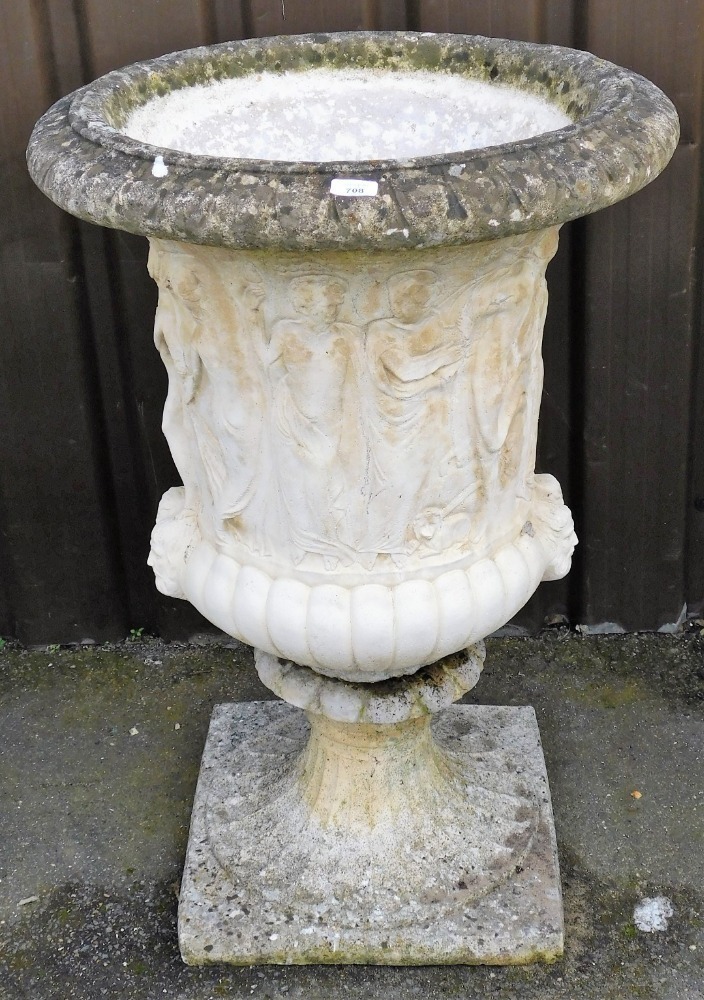 A reconstituted garden urn, of partially fluted form, with twin mask ...