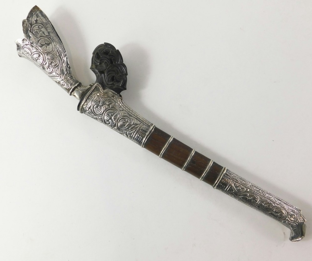 A Malay Sawar white metal mounted dagger, with engraved mounts, horn ...