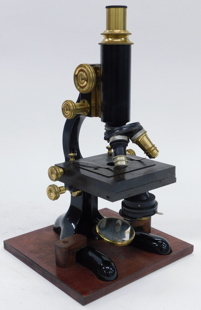 A late 19th/early 20thC brass and ebonised microscope, one lens stamped ...