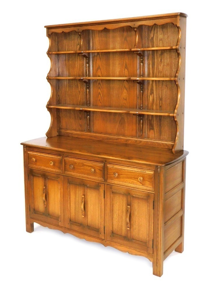 An Ercol elm dresser, with a three shelf waterfall plate rack, over ...