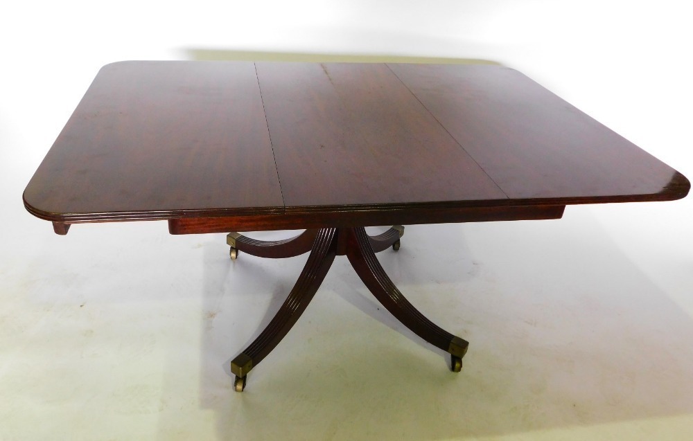A mahogany extending dining table, the rectangular top with a reeded ...