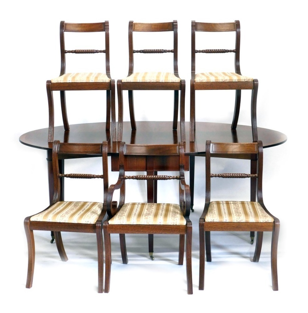 A mahogany oval drop leaf table, with a cross banded border and a ...