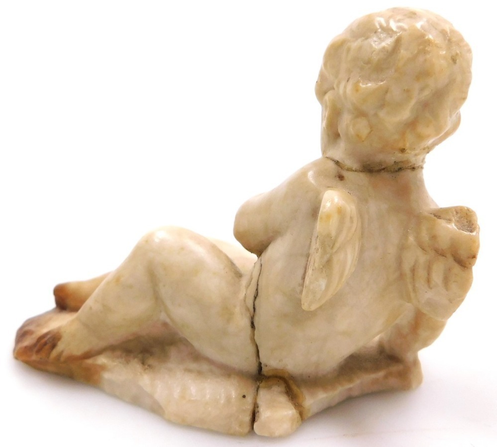 An early 19thC alabaster figure of a reclining putto, 8cm wide, (AF ...