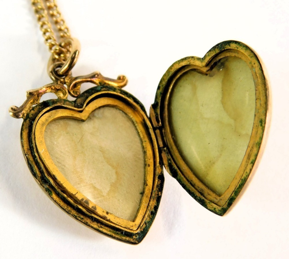 An Edwardian heart shaped locket, set with red and white paste stones ...