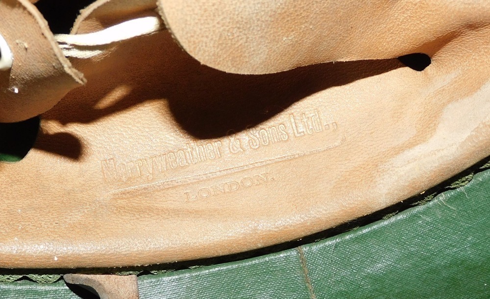 A black pith type fireman's helmet, two collar badges and medallions, a ...