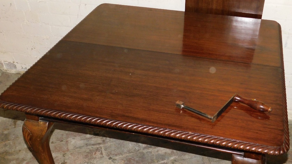A Victorian mahogany wind out dining table, with one additional leaf ...