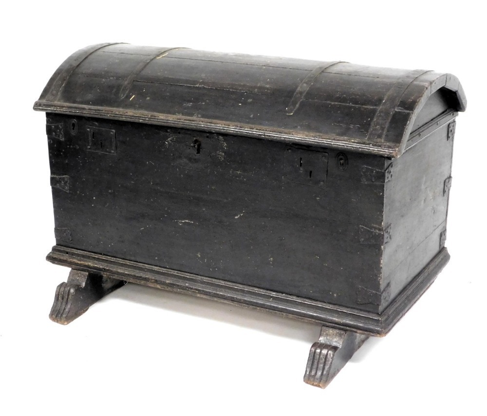A 17thC domed wooden and cast iron bound chest, with three lock plates ...