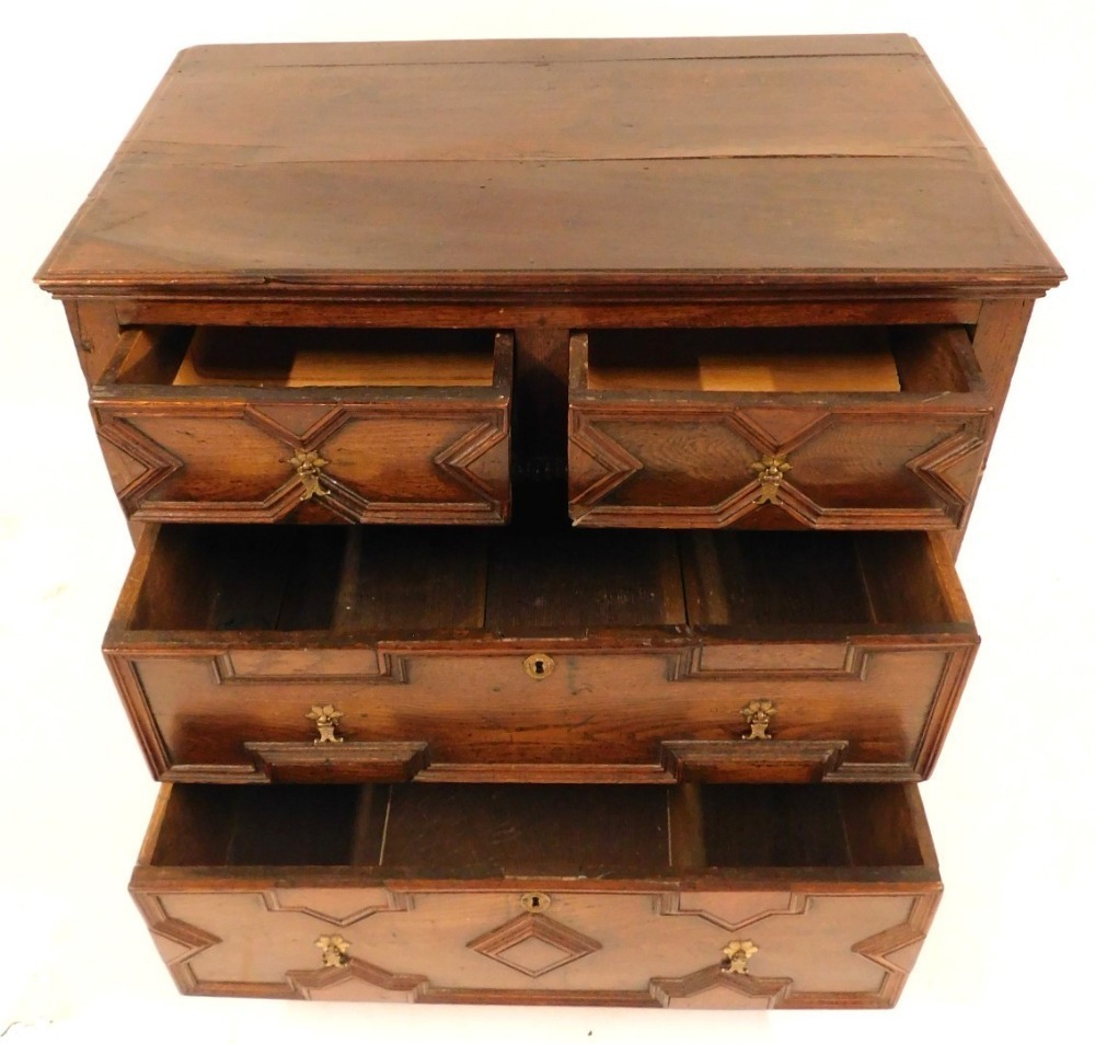 A 17thC oak chest, of two short and two long drawers, with carved cross ...