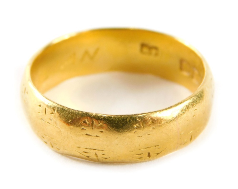 A 22ct gold wedding band, of hammered design, with internal inscription ...