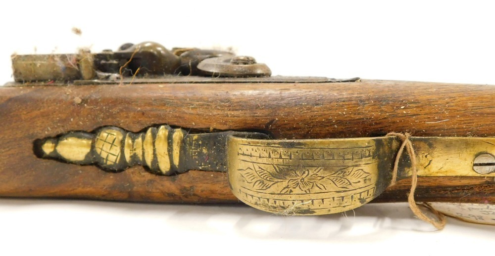 A 19thC left handed flintlock musket by Smith and Co, with brass banded ...