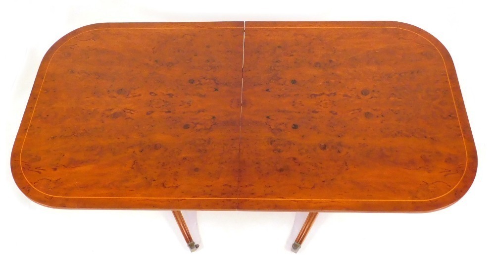 A 20thC reproduction yew wood veneered extending dining table, the ...