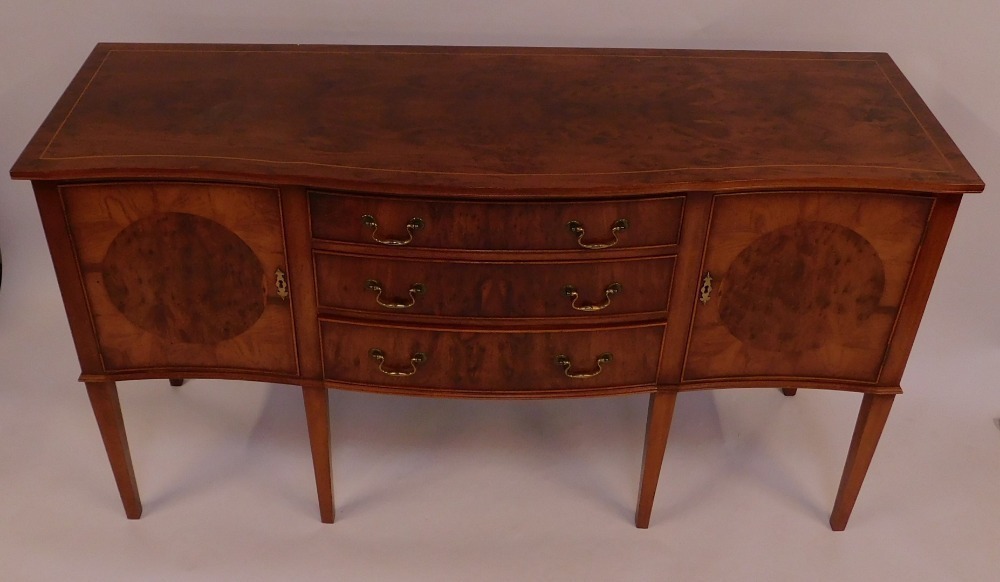 A 20thC reproduction yew wood veneered extending dining table, the ...