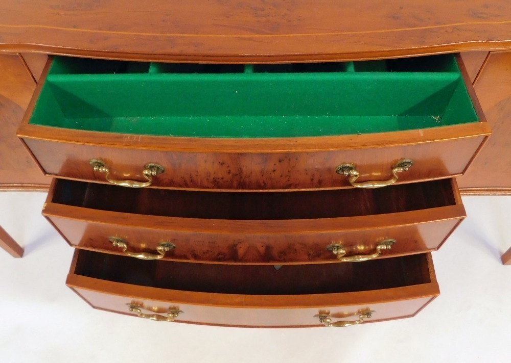 A 20thC reproduction yew wood veneered extending dining table, the ...