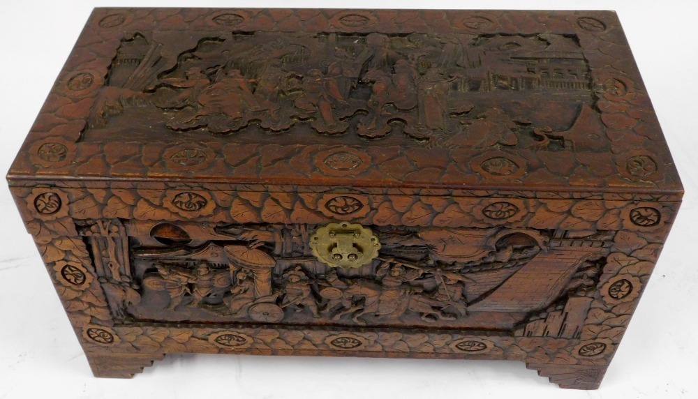 An Oriental camphor wood chest, carved with figures, floral motifs, etc ...