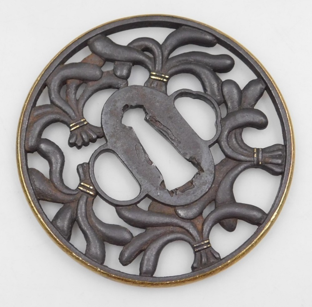 An Edo period iron kyo-shoami tsuba, of circular form, with repeating ...
