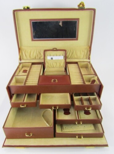 A brown leatherette jewellery box, of three tiered design with brass ...