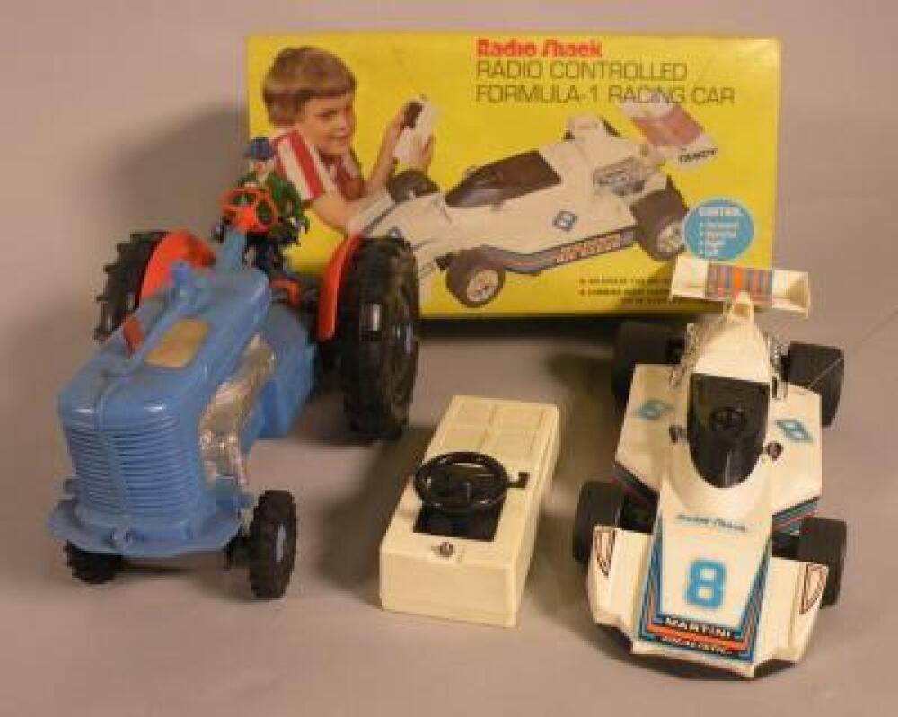 A Radio Shack remote controlled racing car and a battery operated tractor.