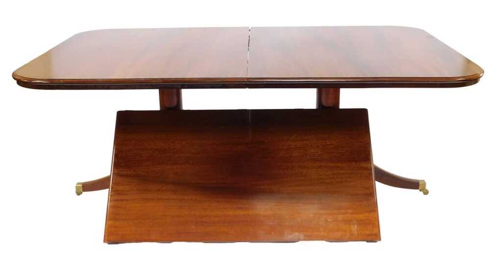 A Georgian style mahogany twin pedestal dining table, raised on turned ...